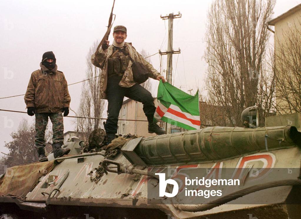 Image of CHECHEN FIGHTERS POSE ATOP APC IN GROZNY, 1999-12-23 (photo)