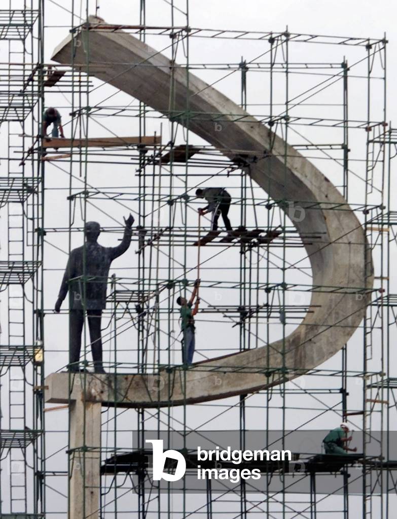 Image of Construction workers erect scaffolding around the monument ...