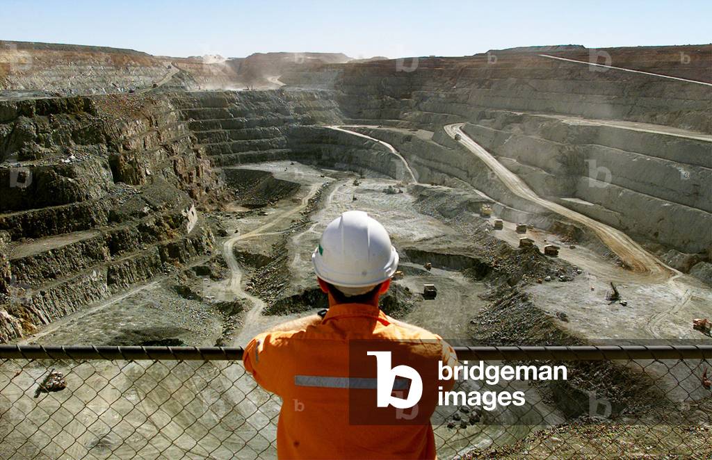 Image of A miner looks across the largest open pit gold mine