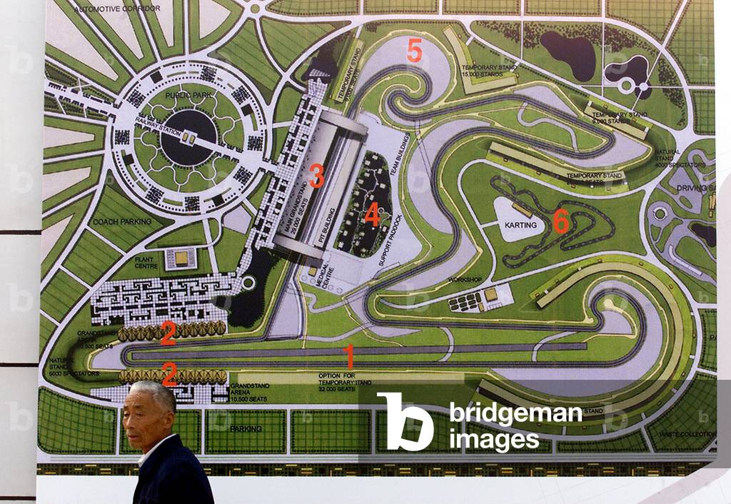 Image of A Chinese resident walks past a floor plan of the