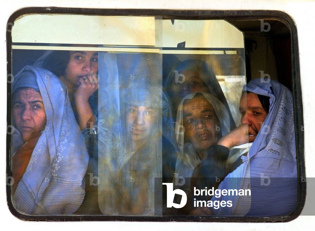 Image of Afghan woman, with their burqas folded back showing their faces,