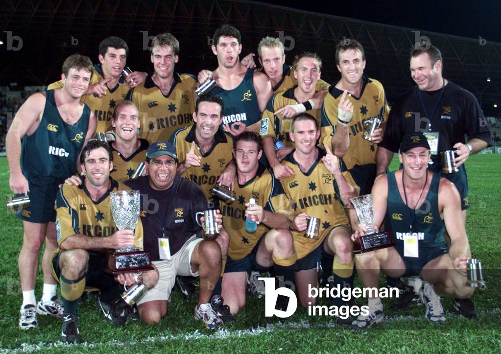 Image of AUSTRALIAN RUGBY PLAYERS POSE WITH THEIR TROPHY AFTER WINNING THE