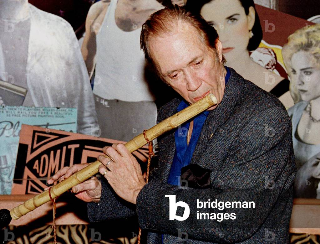 Image of Actor David Carradine demonstrates the bamboo flute he carved and