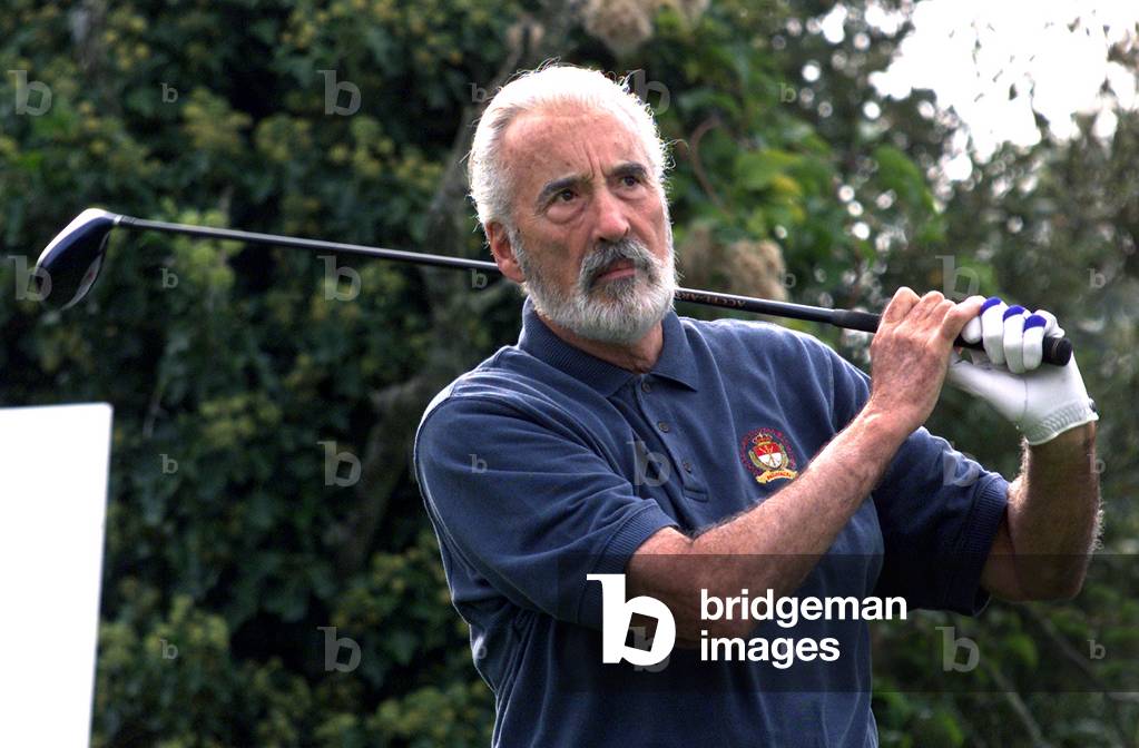 Image of British actor Christopher Lee plays golf as he attends the