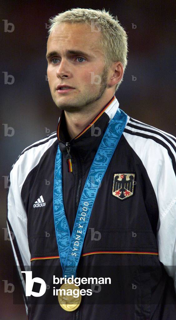 Image of SCHUMANN OF GERMANY STANDS ON THE PODIUM WITH HIS GOLD