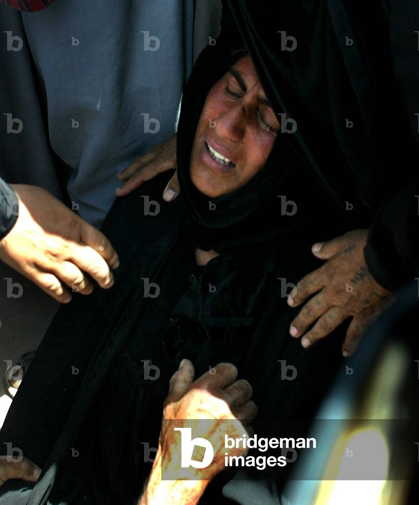 Image of BUSHRA JABBAR IS COMFORTED AFTER IDENTIFYING THE REMAINS OF HER