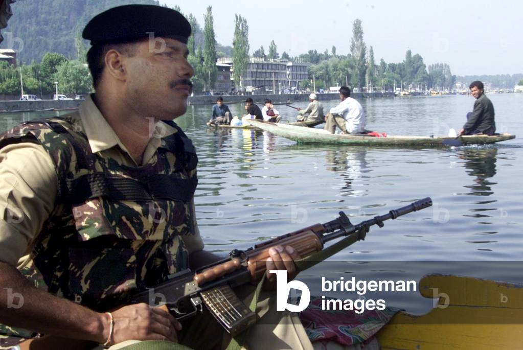 Image of AN INDIAN BORDER SECURITY FORCE TROOPER PATROLS IN A BOAT