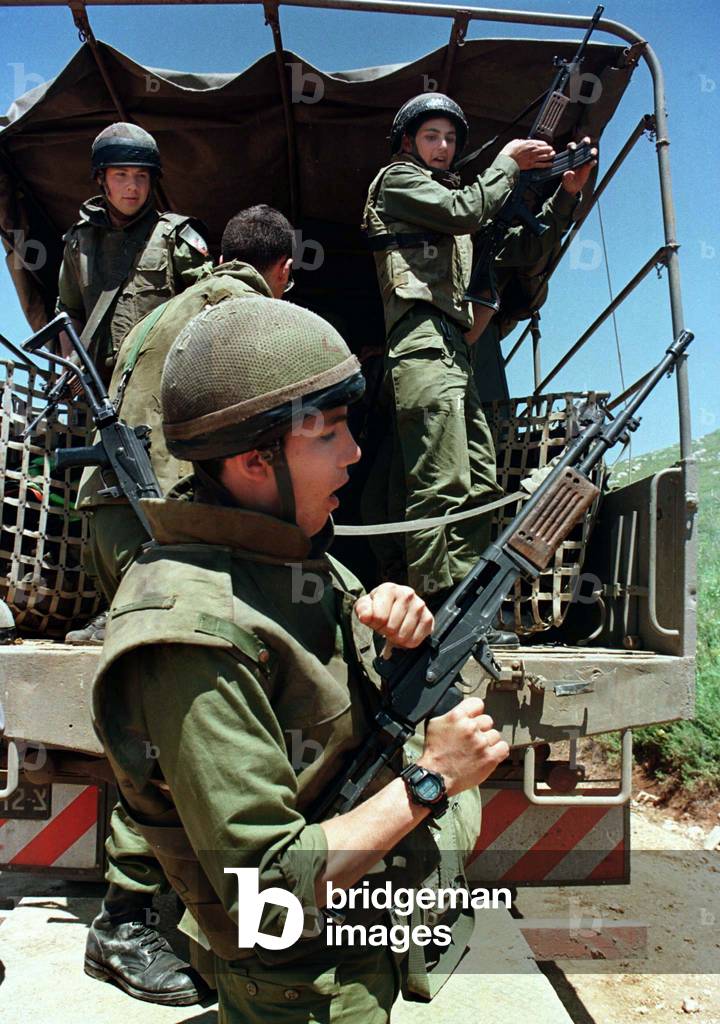 Image of Israeli soldiers check their Galil rifles and load clips of
