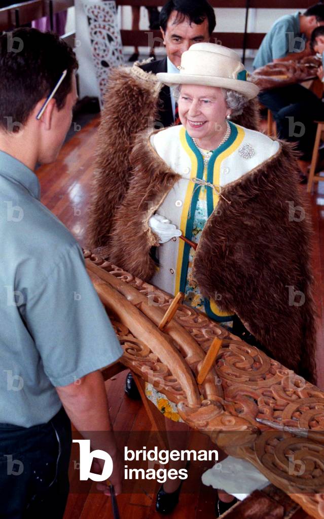 Image of Queen Elizabeth II smiles while talking to a carver at