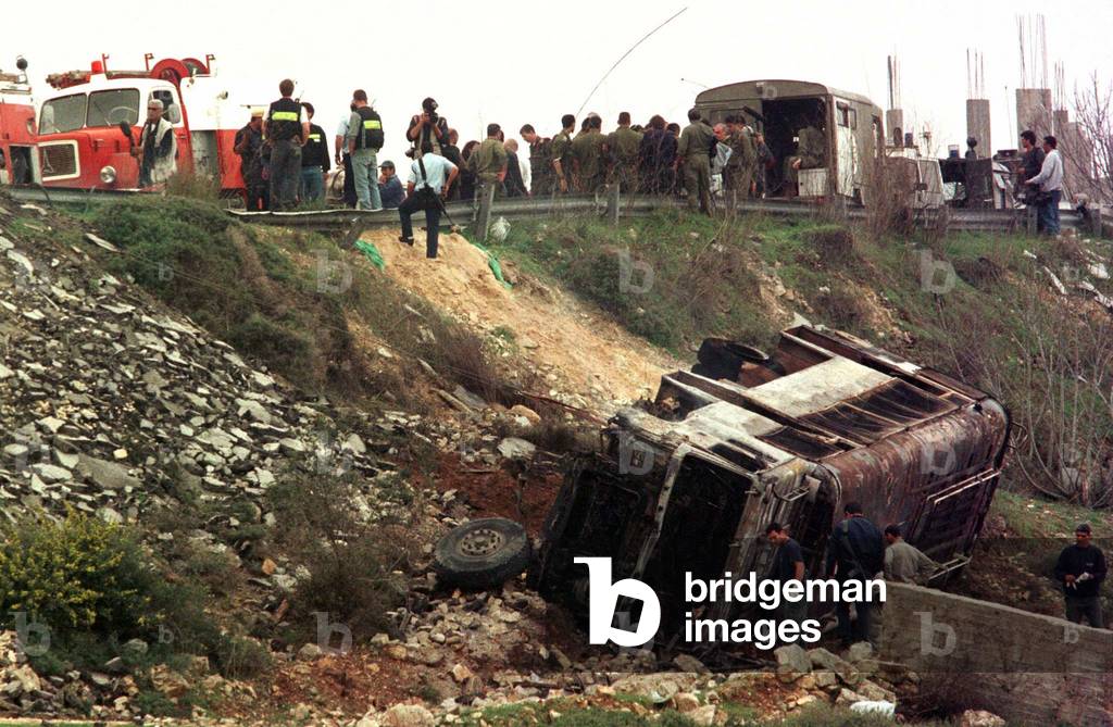 Image of An Israeli army bus is overturned and burnt out after