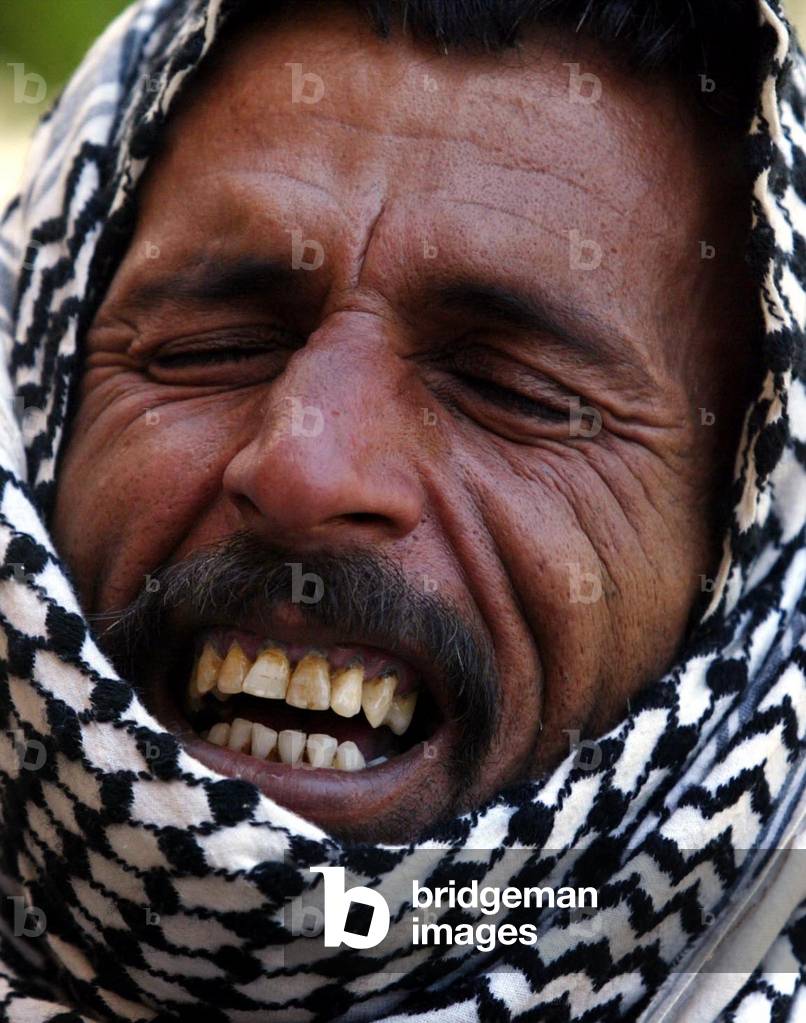 Image of AN IRAQI MAN WEEPS OUTSIDE A HOSPITAL IN TOWN OF