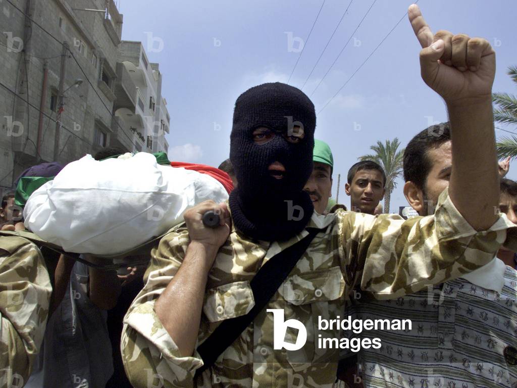 Image of MASKED PALESTINIAN MEMBER OF HAMAS MOVEMENT MARCHES DURING ...