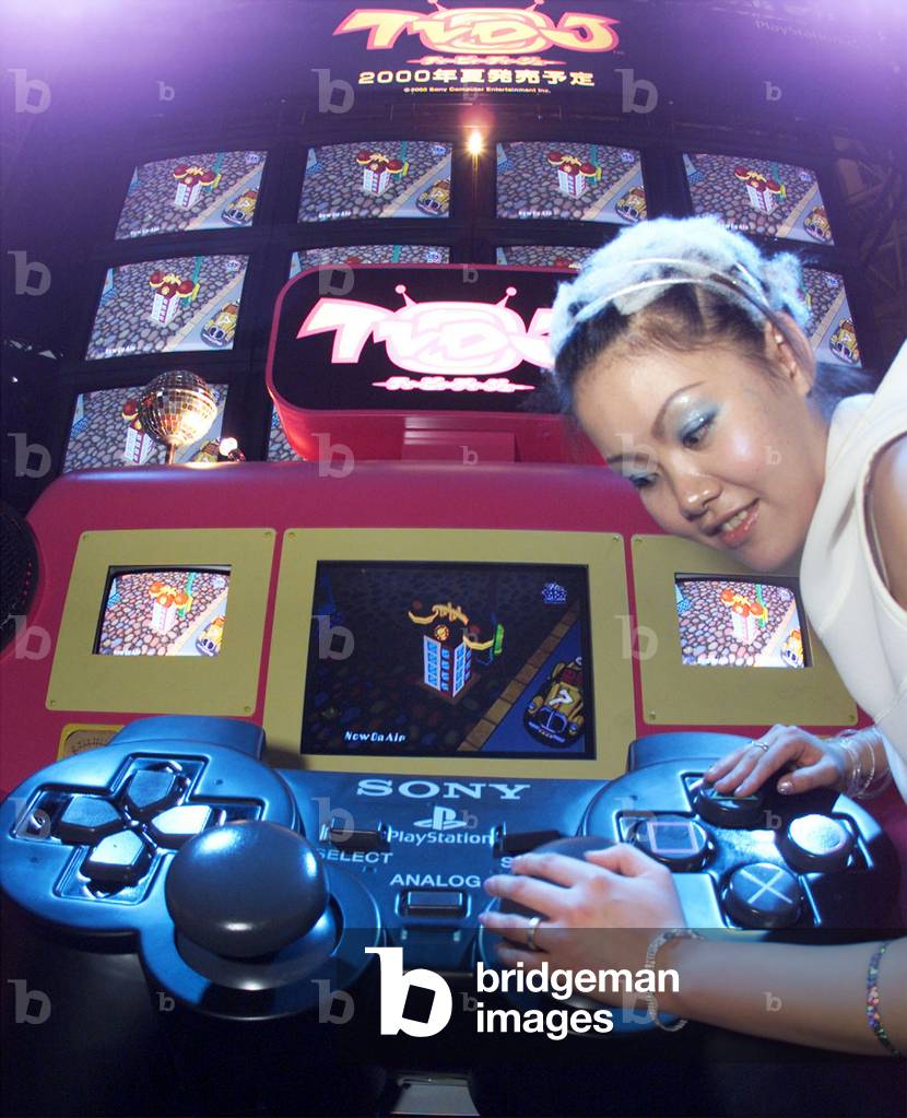 Image of A Japanese visitor tries out the new PlayStation 2 developed