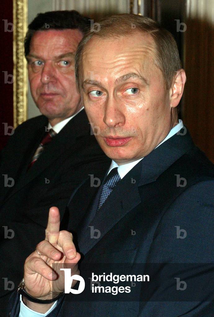 Image of Russian President Vladimir Putin (R) gestures with a finger as