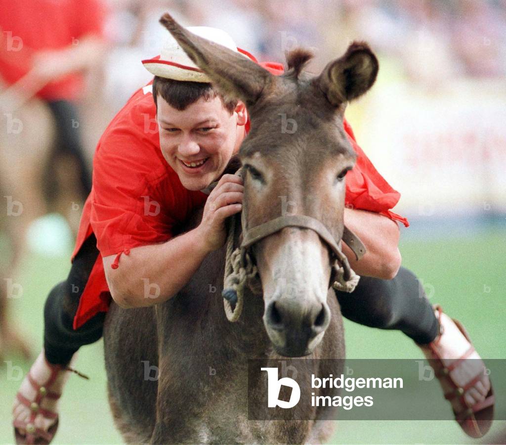 Image of PARTICIPANT IN A DONKEY RACE IN MENDRISIO TRIES TO KEEP