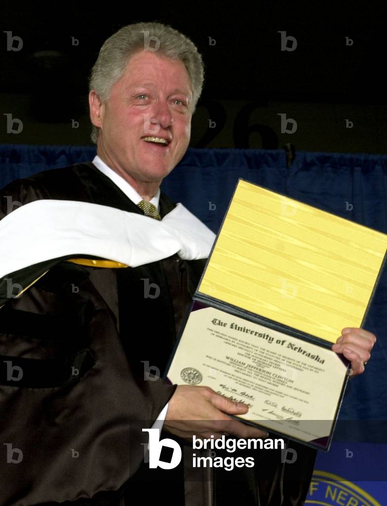 Image of U.S. President Bill Clinton holds an honorary degree presented by