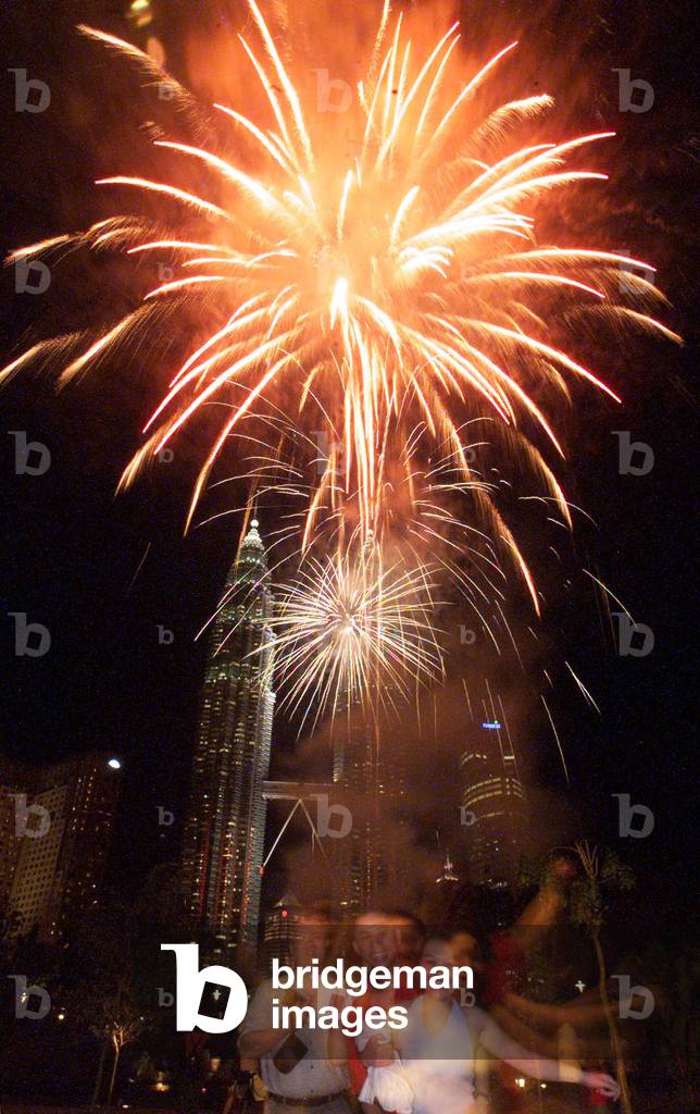 Image of Malaysians celebrate as fireworks explode over the world's ...