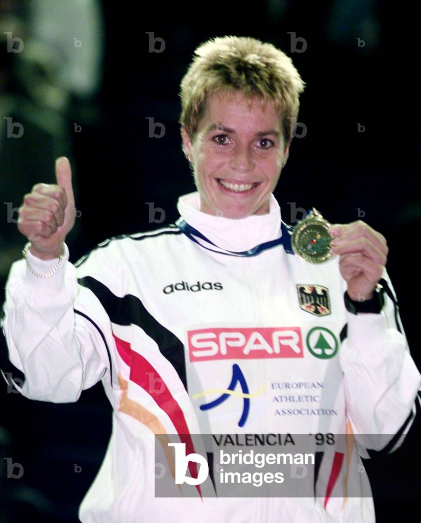 Image of German Grit Breuer shows off her gold medal on podium