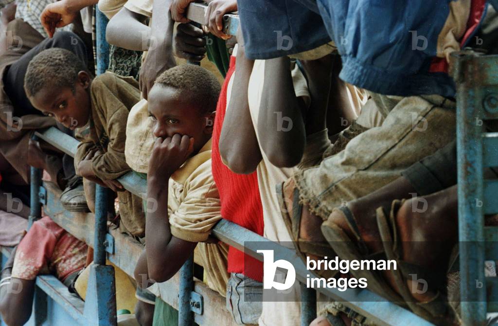 Image of Little Rwandan refugees boys stare out from inside a crowded