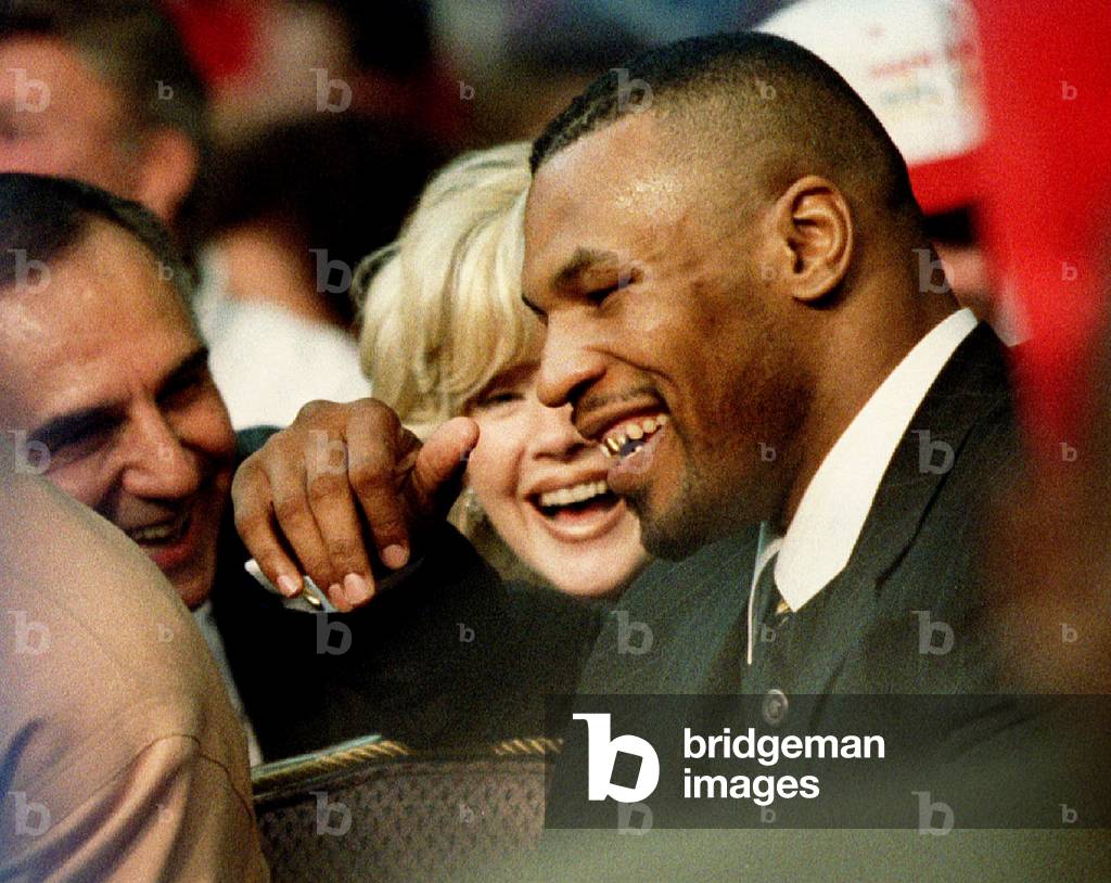 Image of Heavyweight boxer Mike Tyson chats with other spectators at ...