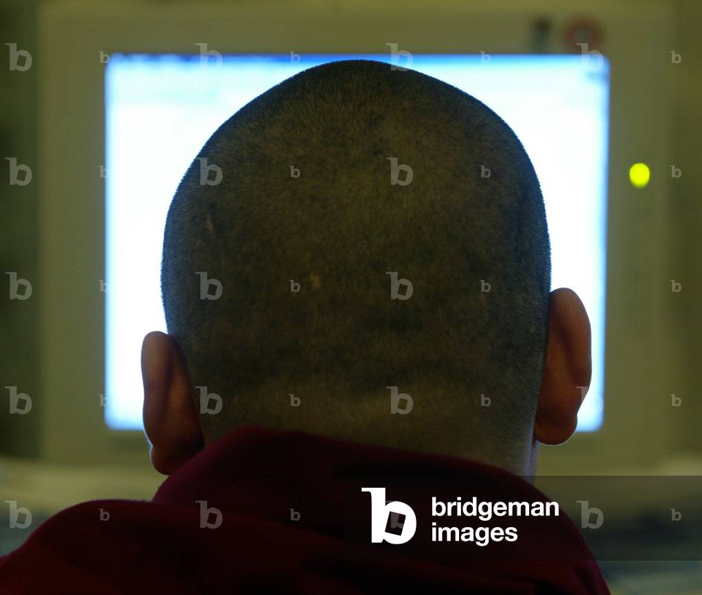 Image of A TIBETAN BUDDHIST MONK CHECKS THE INTERNET BEFORE THE CLOSING