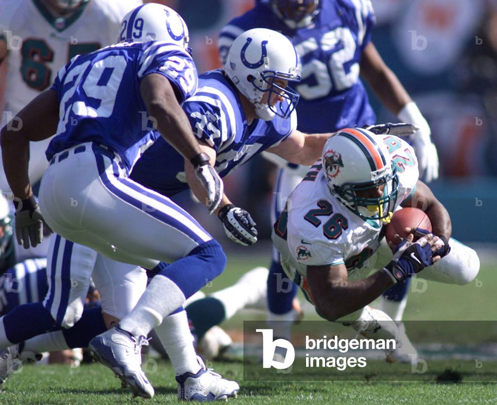 Image of DOLPHINS SMITH IS BROUGHT DOWN BY COLTS COTA AND BELSER,