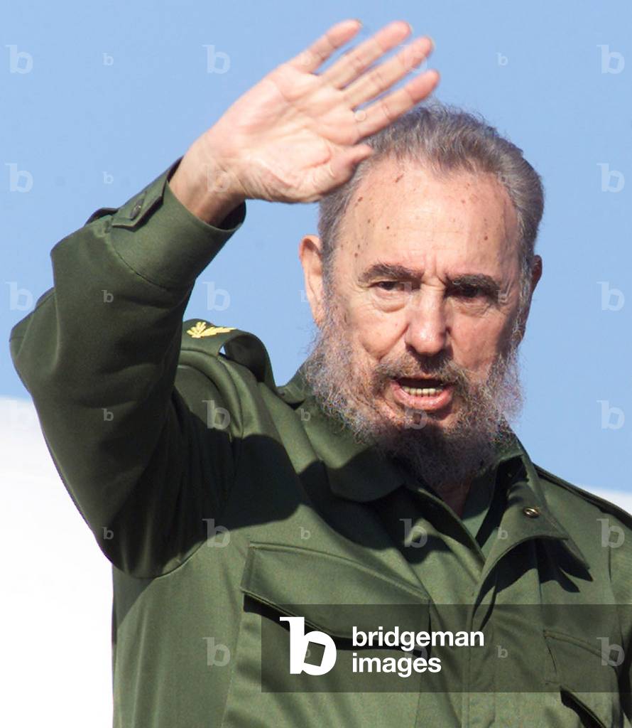 Image of Cuban President Fidel Castro waves from the steps of his