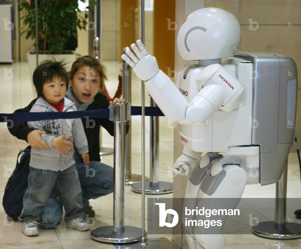 Image of MOTHER AND CHILD WATCH HONDA MOTOR'S HUMANOID ROBOT ASIMO MAKE