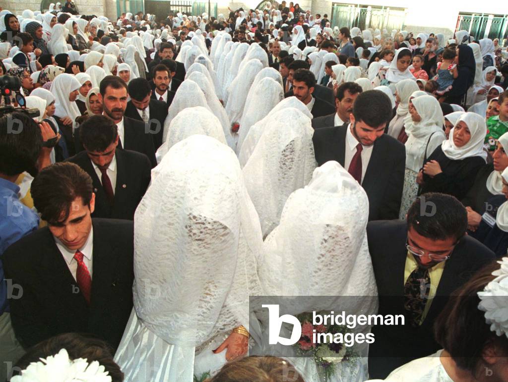 Image of MOSELM MEN AND THEIR VEILED BRIDES AT A MASS WEDDING
