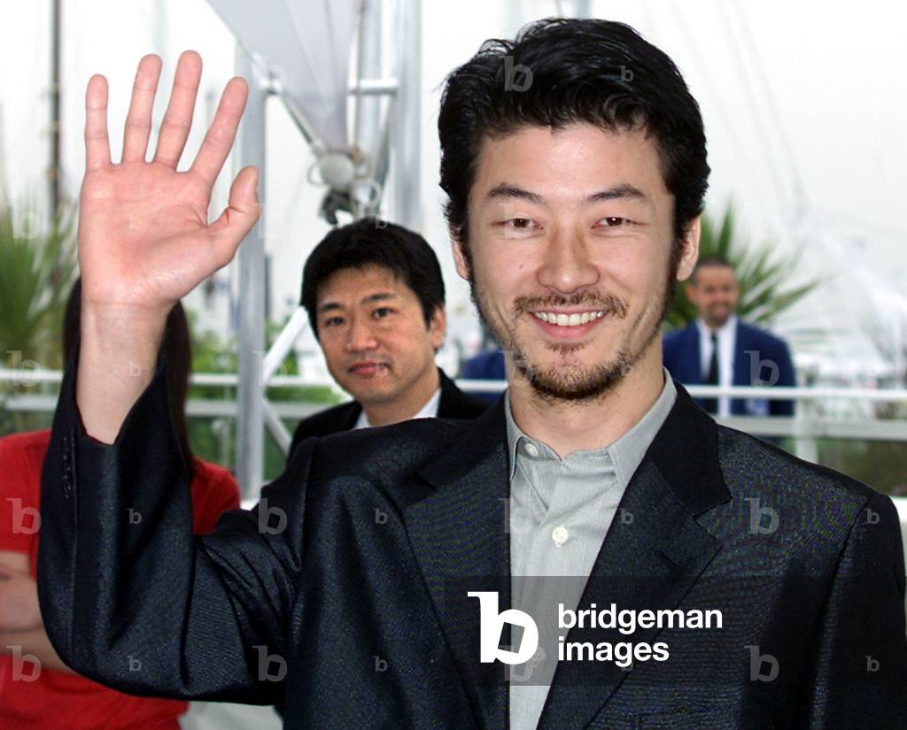 Image of Japanese actor Asano Tadanobu waves as Japanese director Kore-Eda Hirokazu
