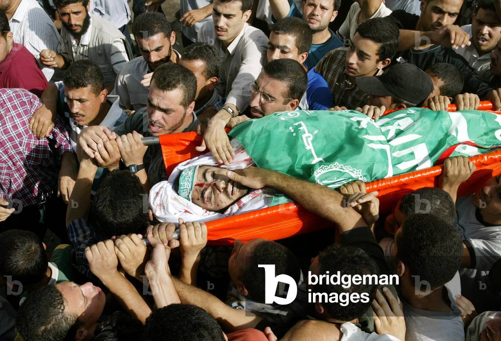 Image of Hamas supporters carry the body of Khaled, the son of