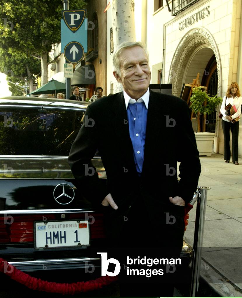 Image of Playboy magazine founder Hugh Hefner poses for a photograph with
