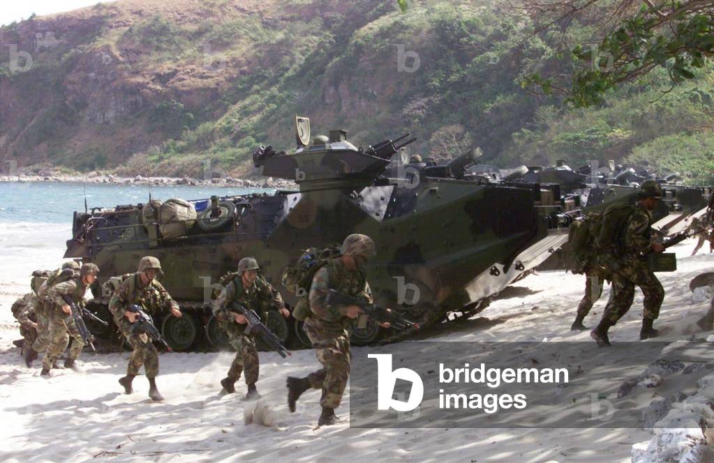 Image of US MARINE SOLDIERS RUN TO TAKE POSITIONS AFTER DISEMBARKING FROM