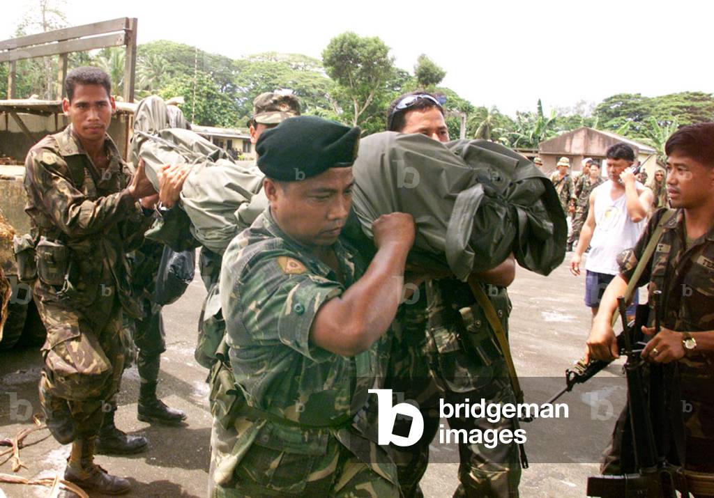 Image of Philippine government soldiers carry the body of one of their