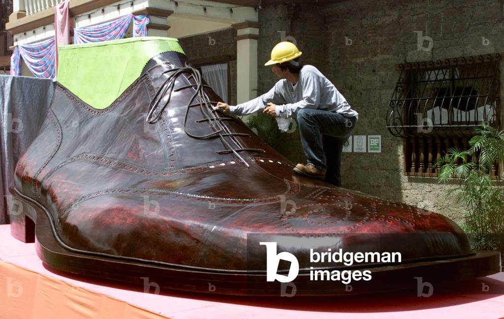 Image of A FILIPINO WORKER CLEANS A WORLD'S LARGEST SHOE IN MARIKINA