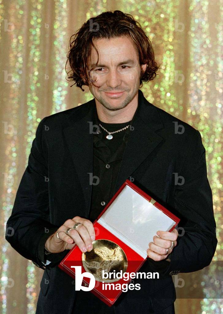Image of Australian film director Baz Luhrmann smiles as he displays the
