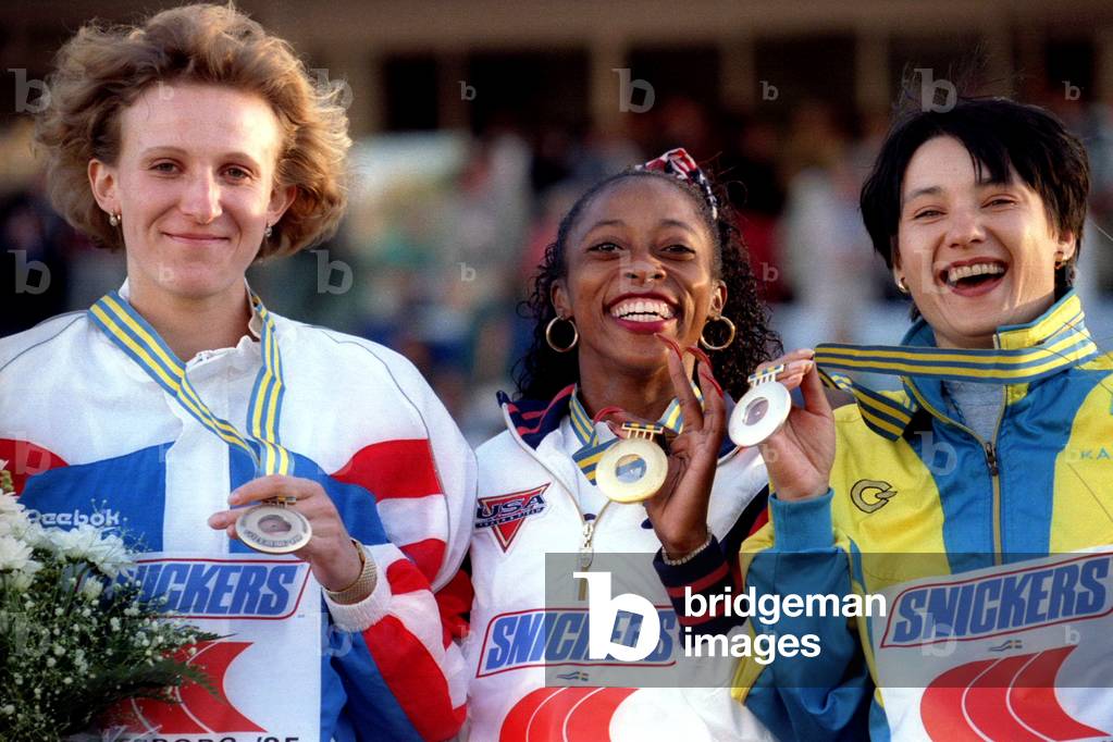 Image of Medal winners in the 100M hurdles event stand together on