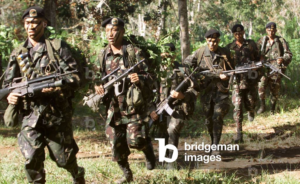 Image of PHILIPPINE SCOUT RANGERS WITH THEIR AUTOMATIC RIFLES RUN DURING A