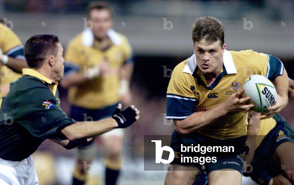 Image of AUSTRALIAS TUNE RUNS TOWARD TRY LINE AS SOUTH AFRICAS GREEFF