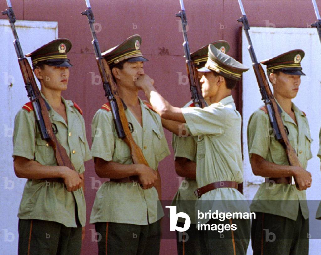 Image of A People's Liberation Army drill instructor taps a soldier on