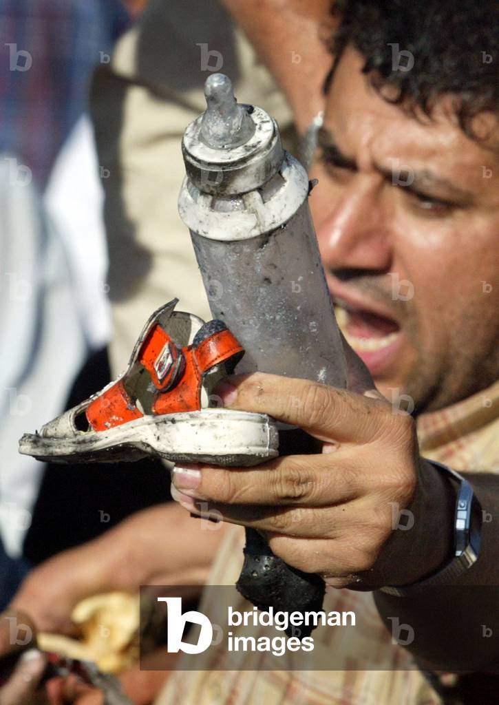 Image of AN ANGRY PALESTINIAN YOUTH HOLDS UP A BABY'S BOTTLE AND