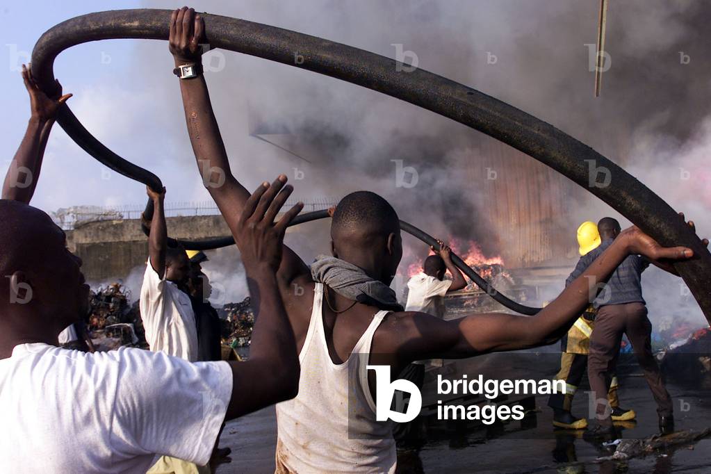 Image of NIGERIAN'S RUN WITH A HOSE PIPE AFTER AN EXPLOSION RIPPED
