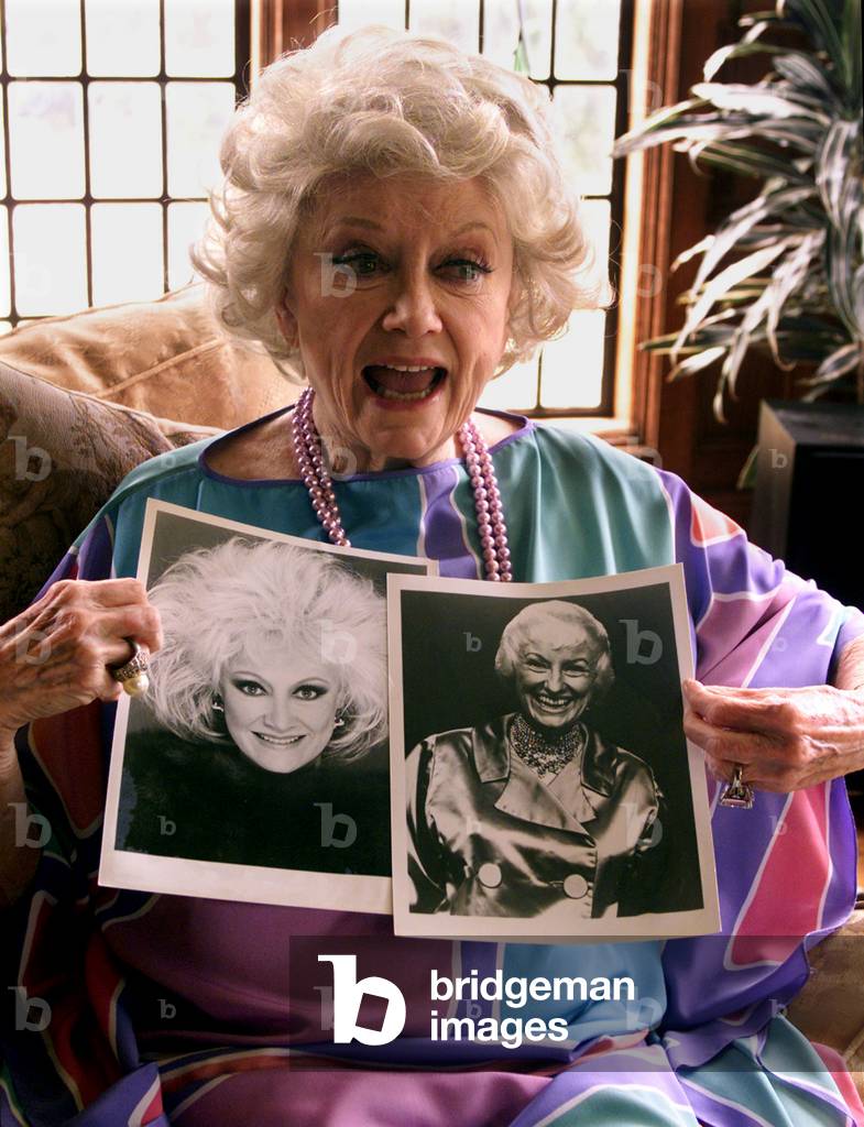Image of Comedienne Phyllis Diller displays some publicity photographs ...