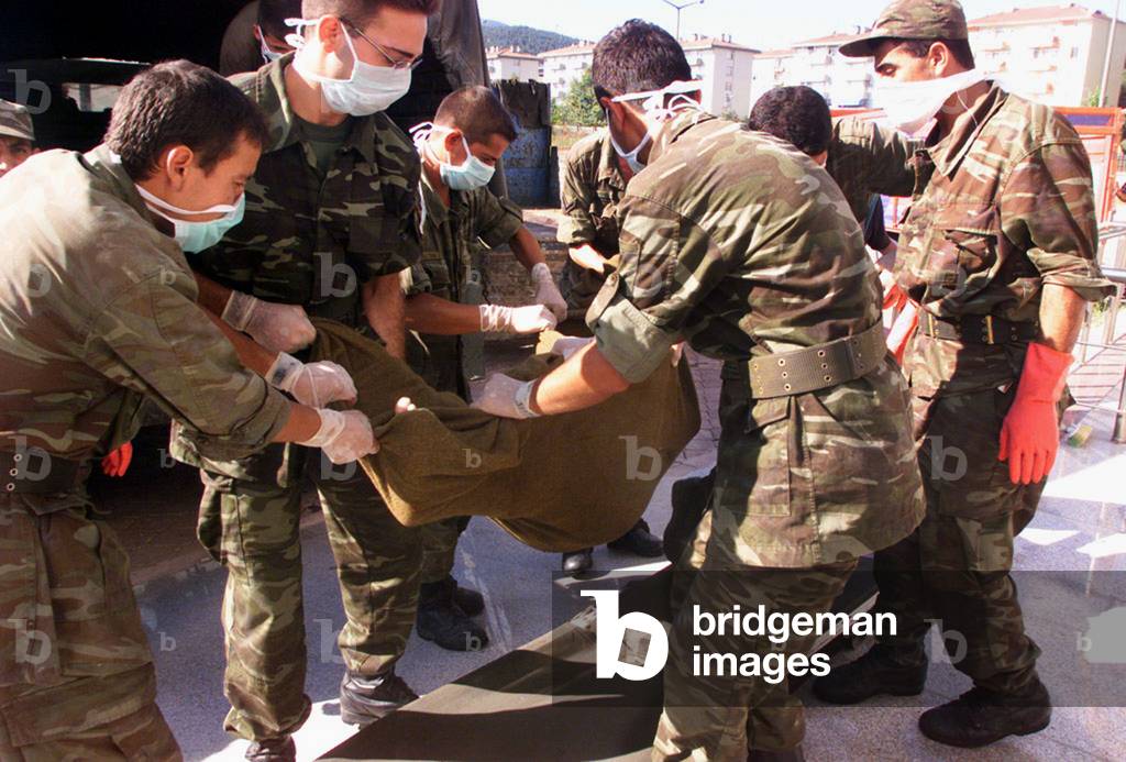 Image of Turkish soldiers, wearing surgical masks, carry a dead quake ...