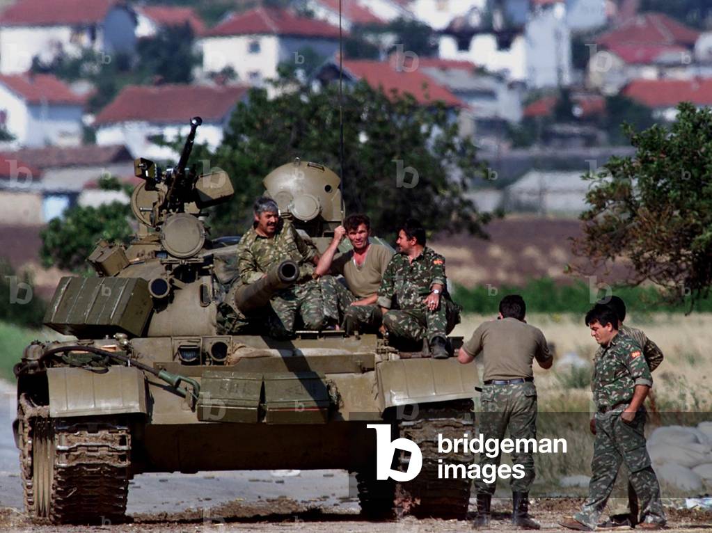 Image of MACEDONIAN ARMY SOLDIERS TAKE A REST ON TOP OF A
