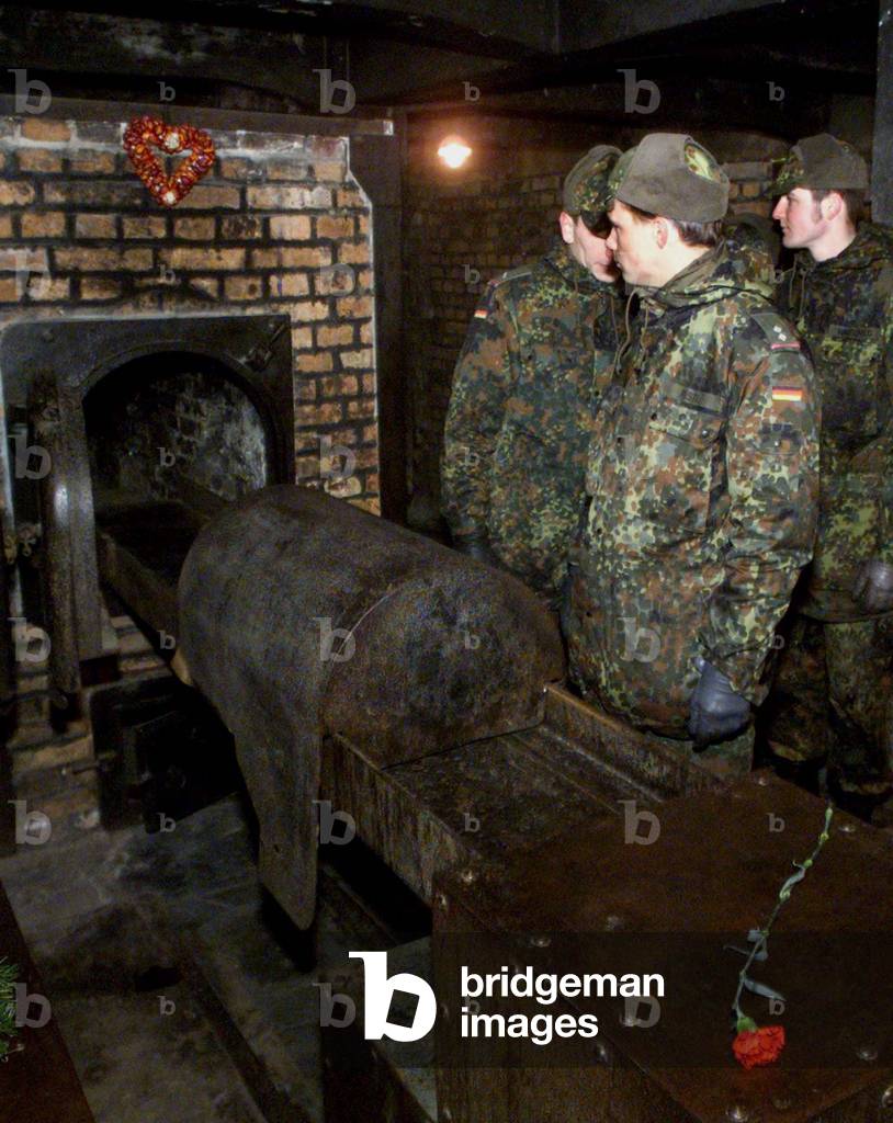 Image of German soldiers look at the crematory stove during their visit