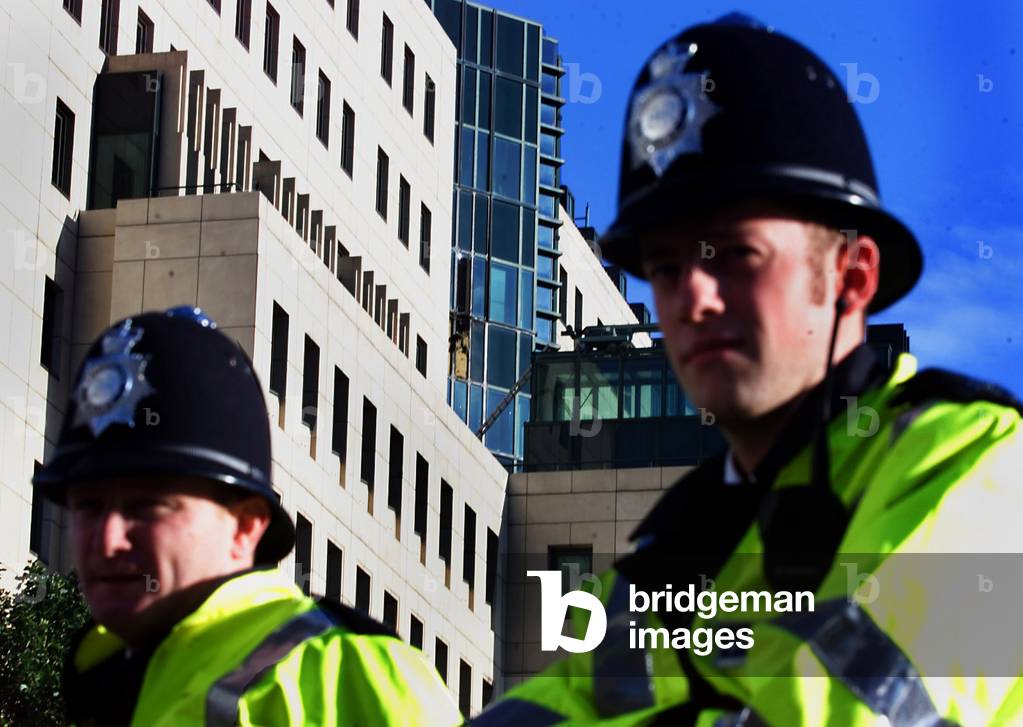 Image of British Police officers stand in front of the headquarters of