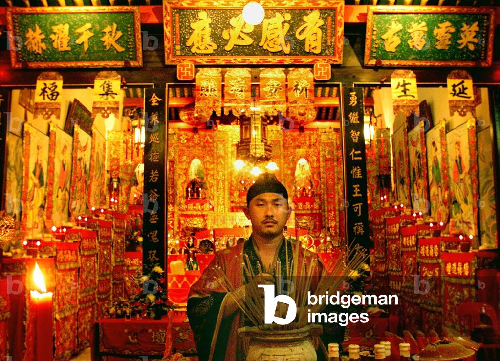 Image of A MALAYSIAN OF CHINESE DESCENT RECITES A PRAYER DURING THE