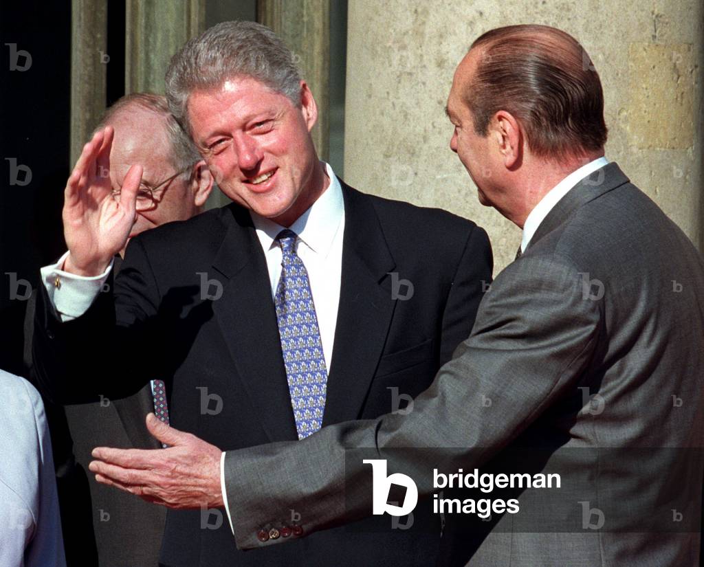 Image of U.S President Bill Clinton waves as he is accompanied by