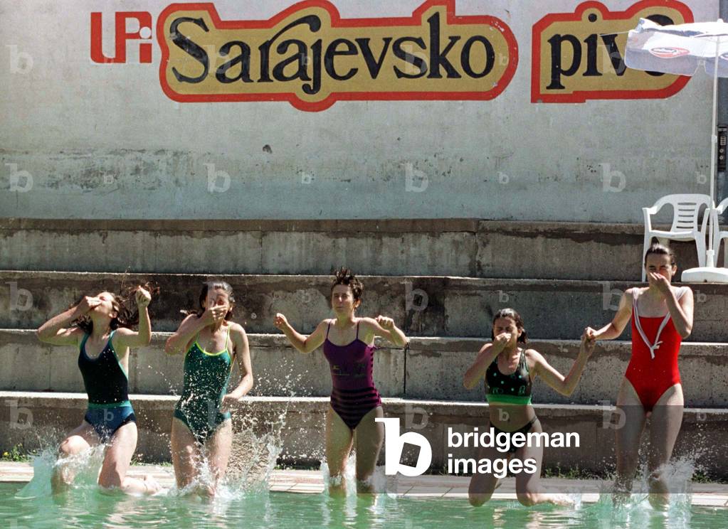 Image of A group of high school girls jump into a swimming